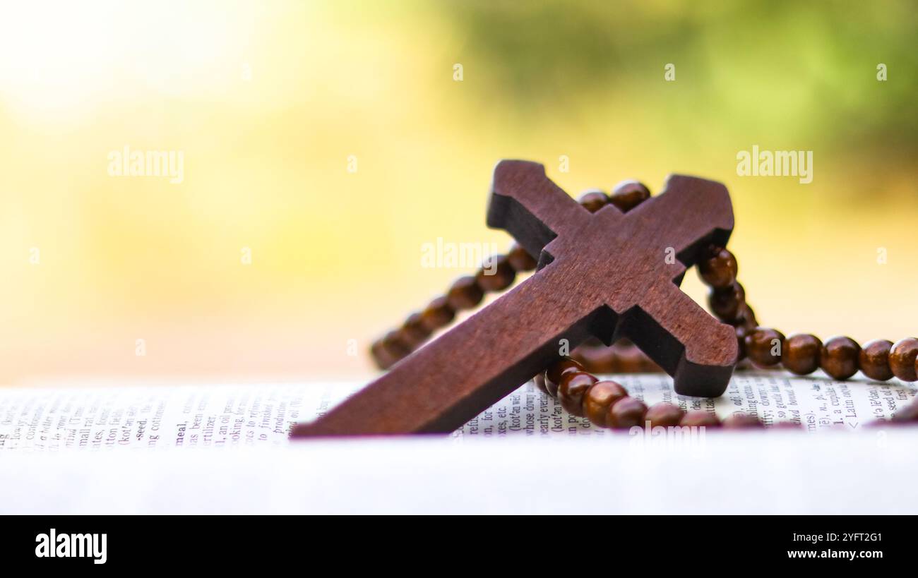 Brown wooden cross on an old open book symbolizing the spread of Jesus ...