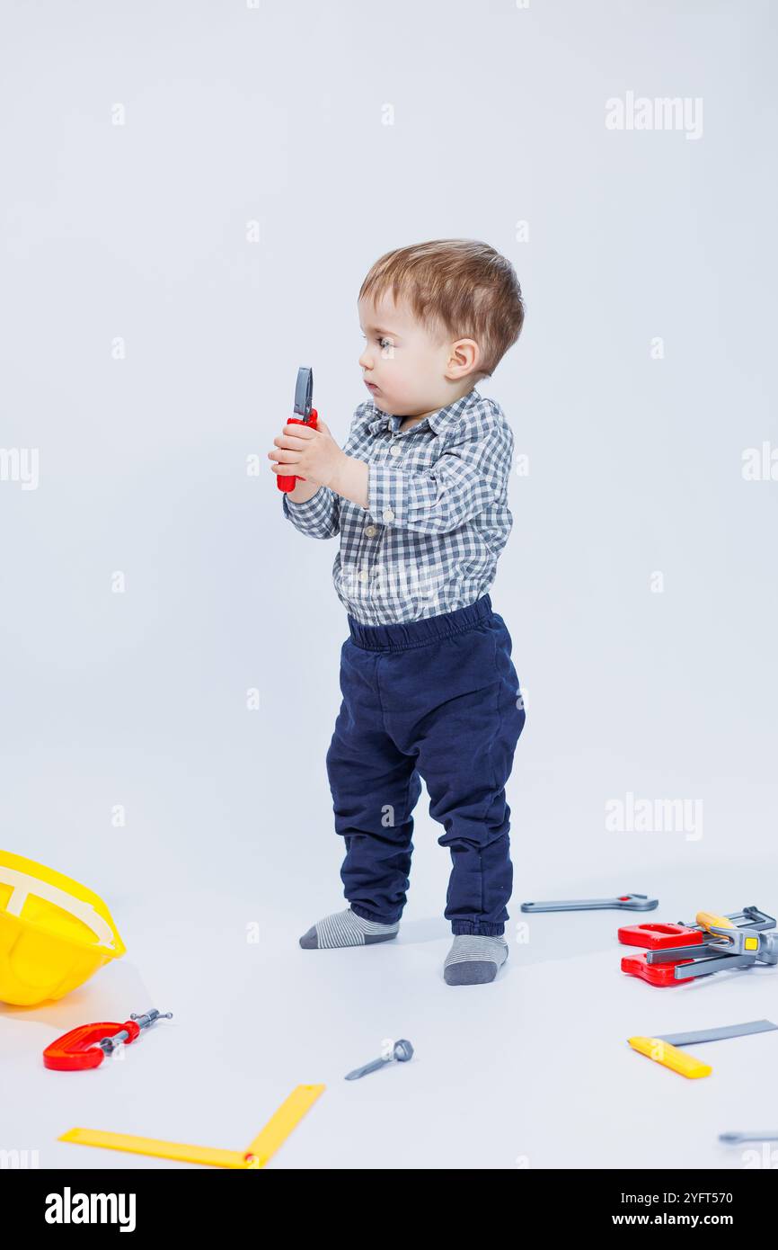 A cute boy in a shirt in the image of a builder, on a white background ...