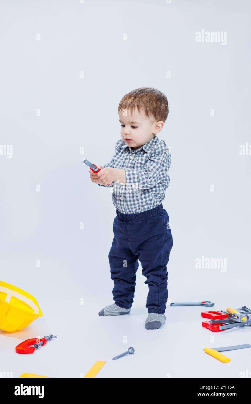 A cute boy in a shirt in the image of a builder, on a white background ...