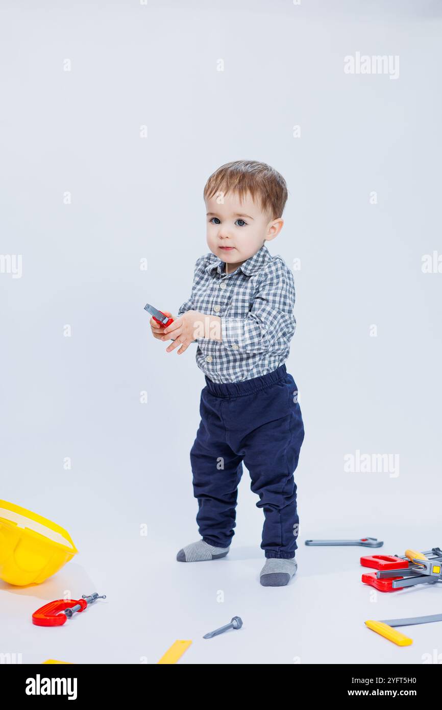 A cute boy in a shirt in the image of a builder, on a white background ...