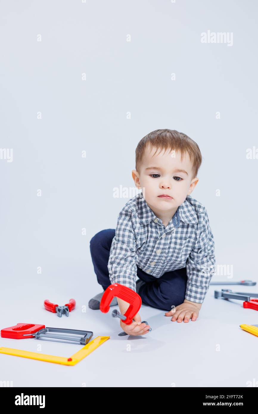 A cute boy in a shirt in the image of a builder, on a white background ...