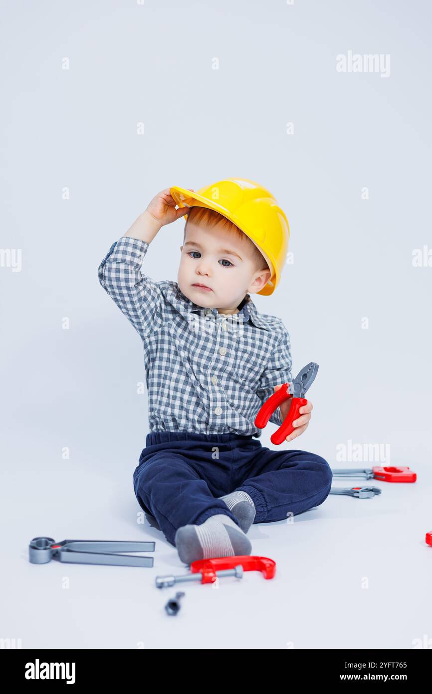 A cute boy in a shirt in the image of a builder, on a white background ...