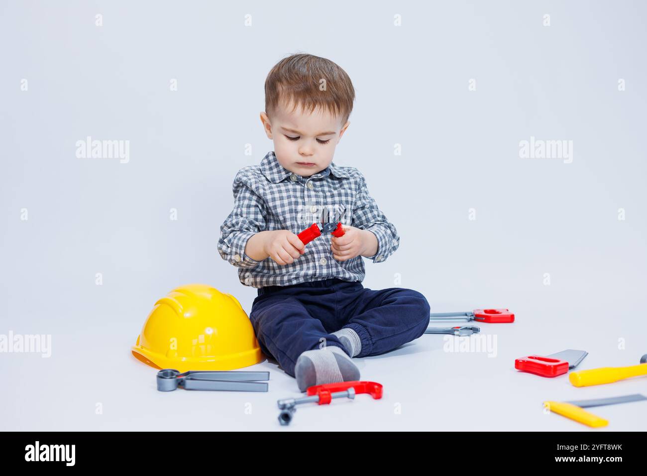 A cute boy in a shirt in the image of a builder, on a white background ...