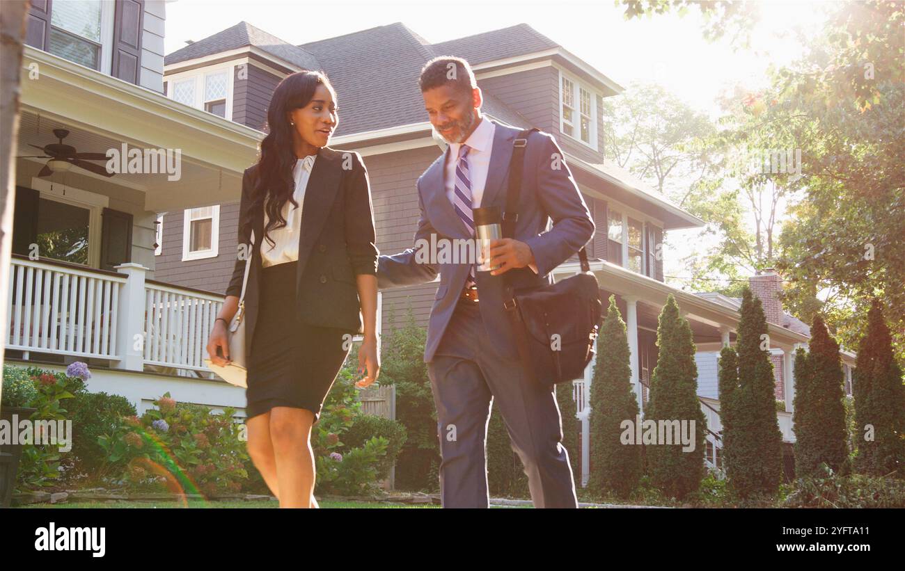 Business Couple Leaving Suburban House For Commute To Work Stock Photo ...