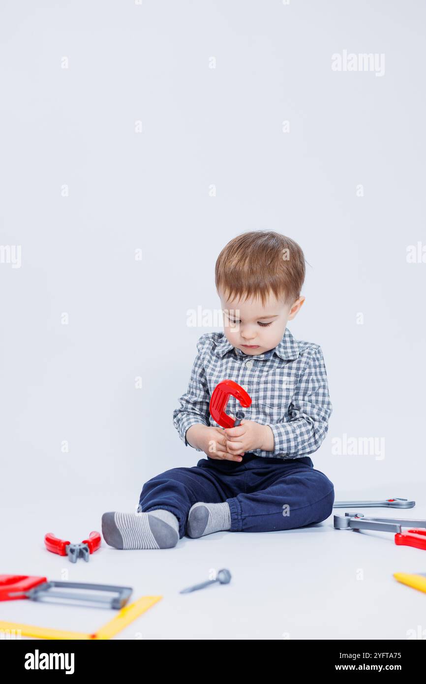 A cute boy in a shirt in the image of a builder, on a white background ...