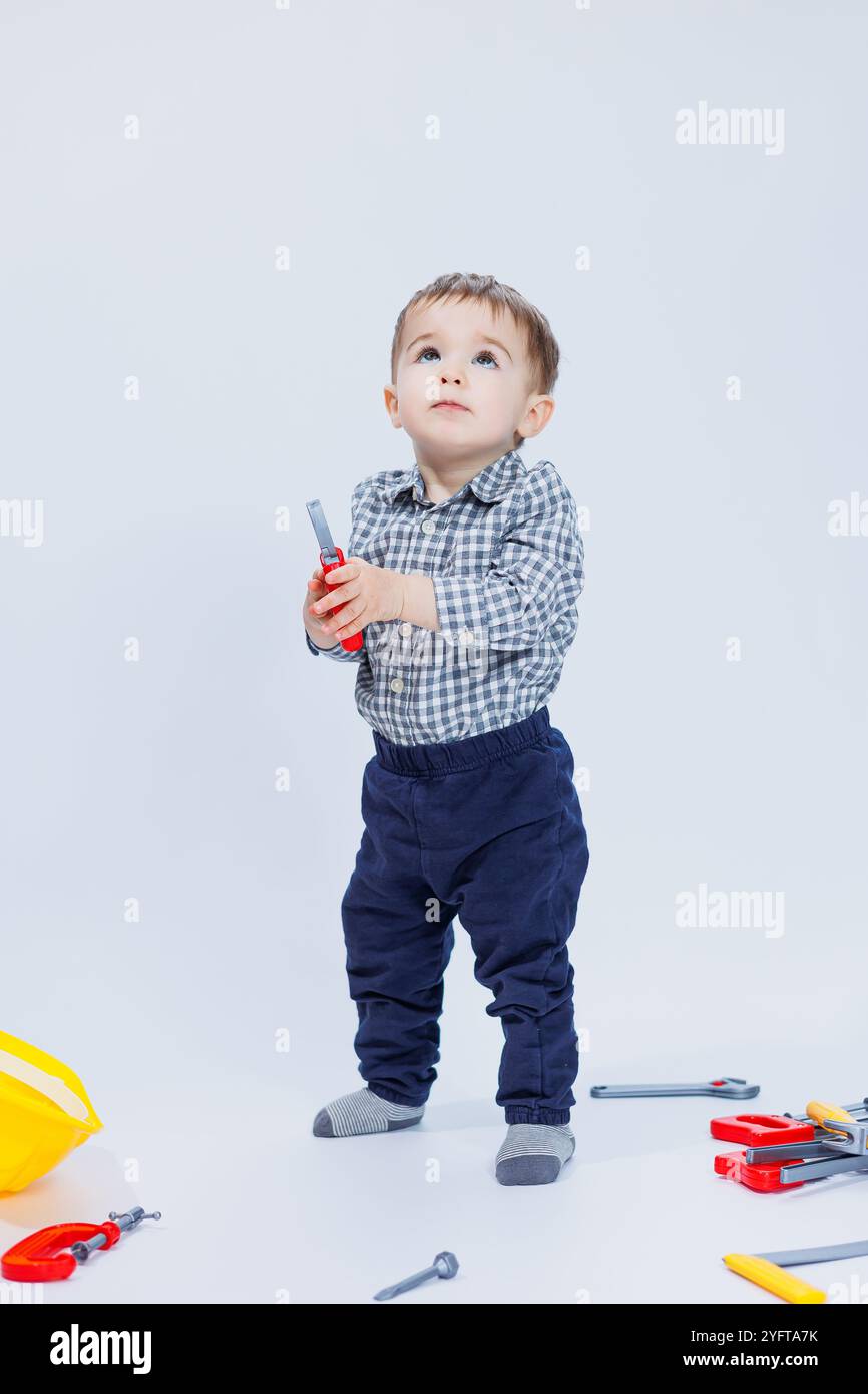 A cute boy in a shirt in the image of a builder, on a white background ...