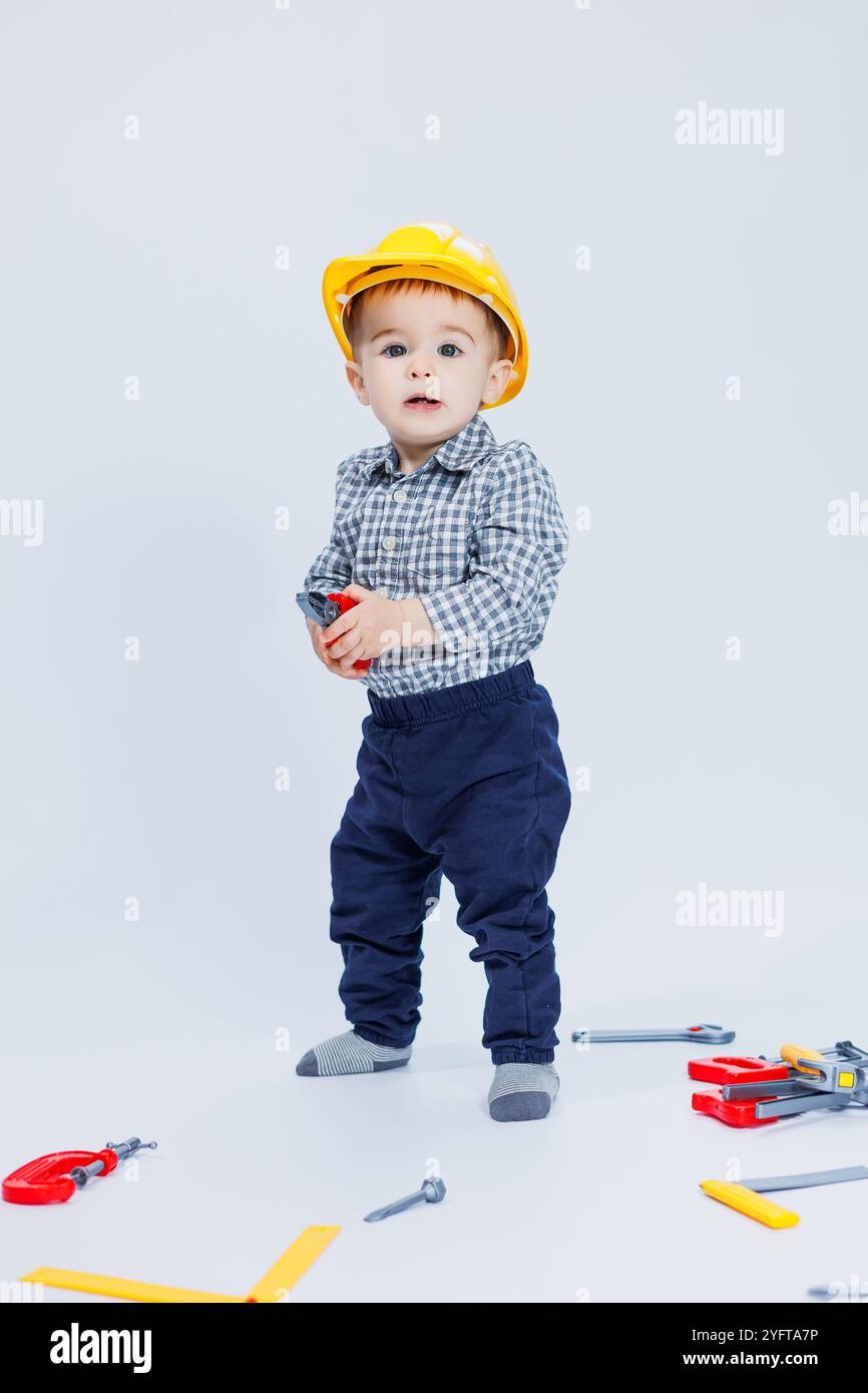 A cute boy in a shirt in the image of a builder, on a white background ...