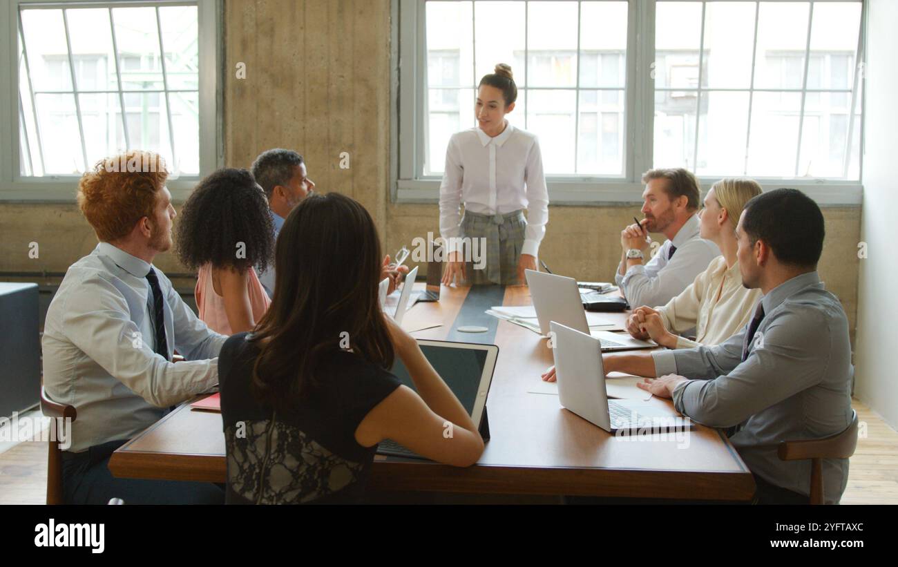 Young Businesswoman Giving Presentation To Multi-Cultural Team Sitting ...
