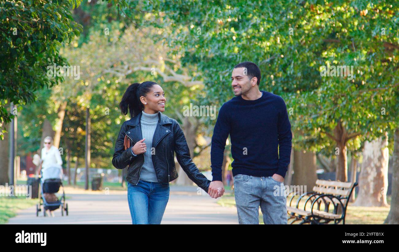 Loving Young Couple Outdoors Walking Through Park Holding Hands ...