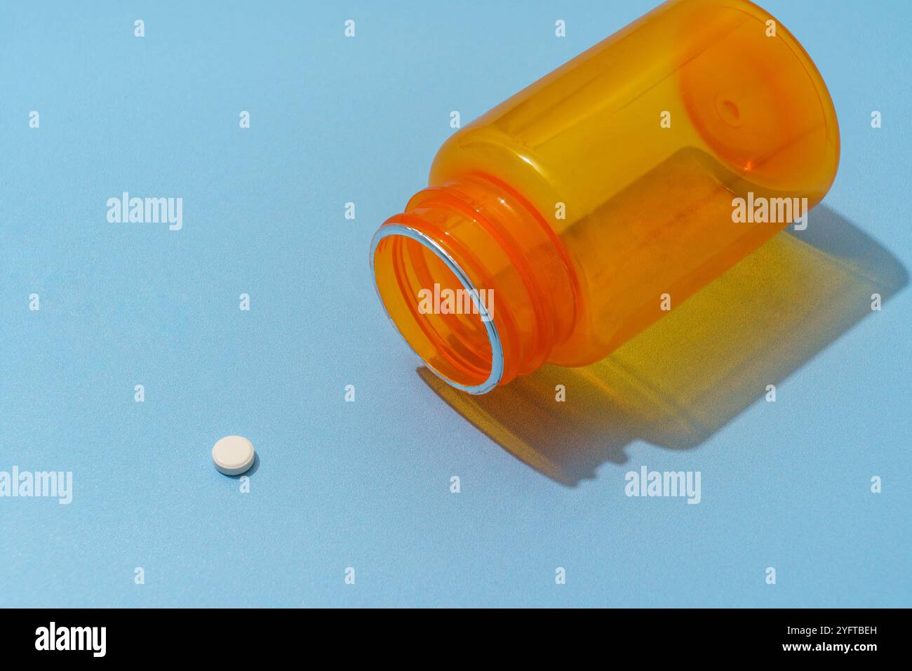 Orange Plastic Pill Bottle lies on its side with a White Medication ...