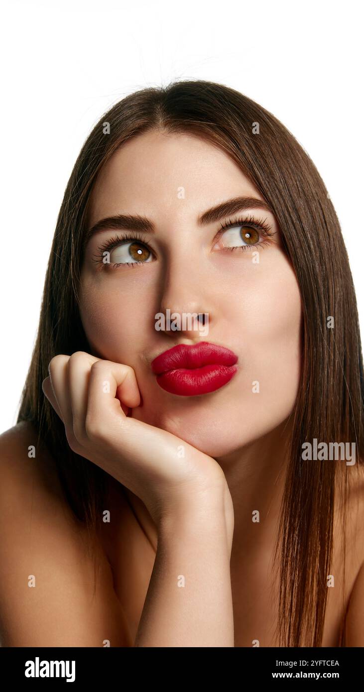 Pretty woman looks chic with red lipstick on lips, purses lips to make ...