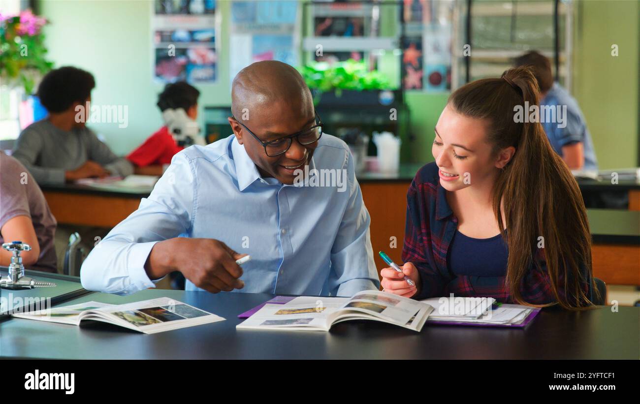 Female High School Student Receiving Individual Attention From Teacher ...