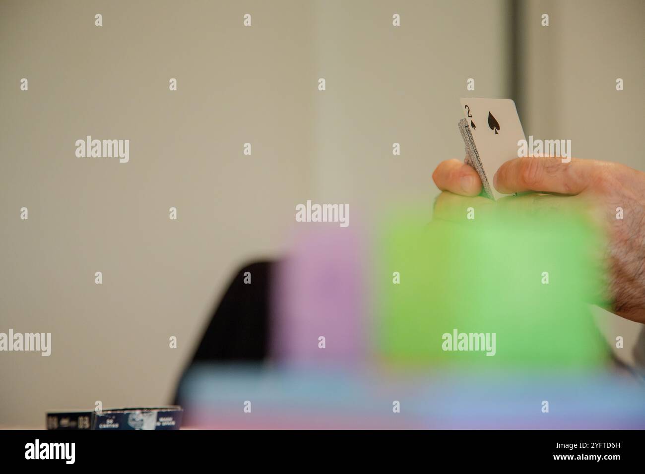 A group of people gather around a table playing cards, a casual game ...