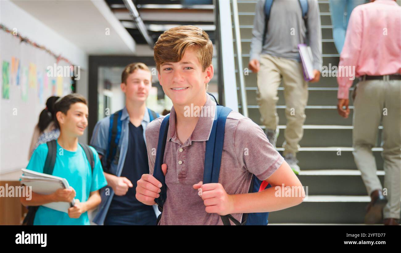 Portrait Of Smiling Male High School Student Standing By Stairs In Busy ...