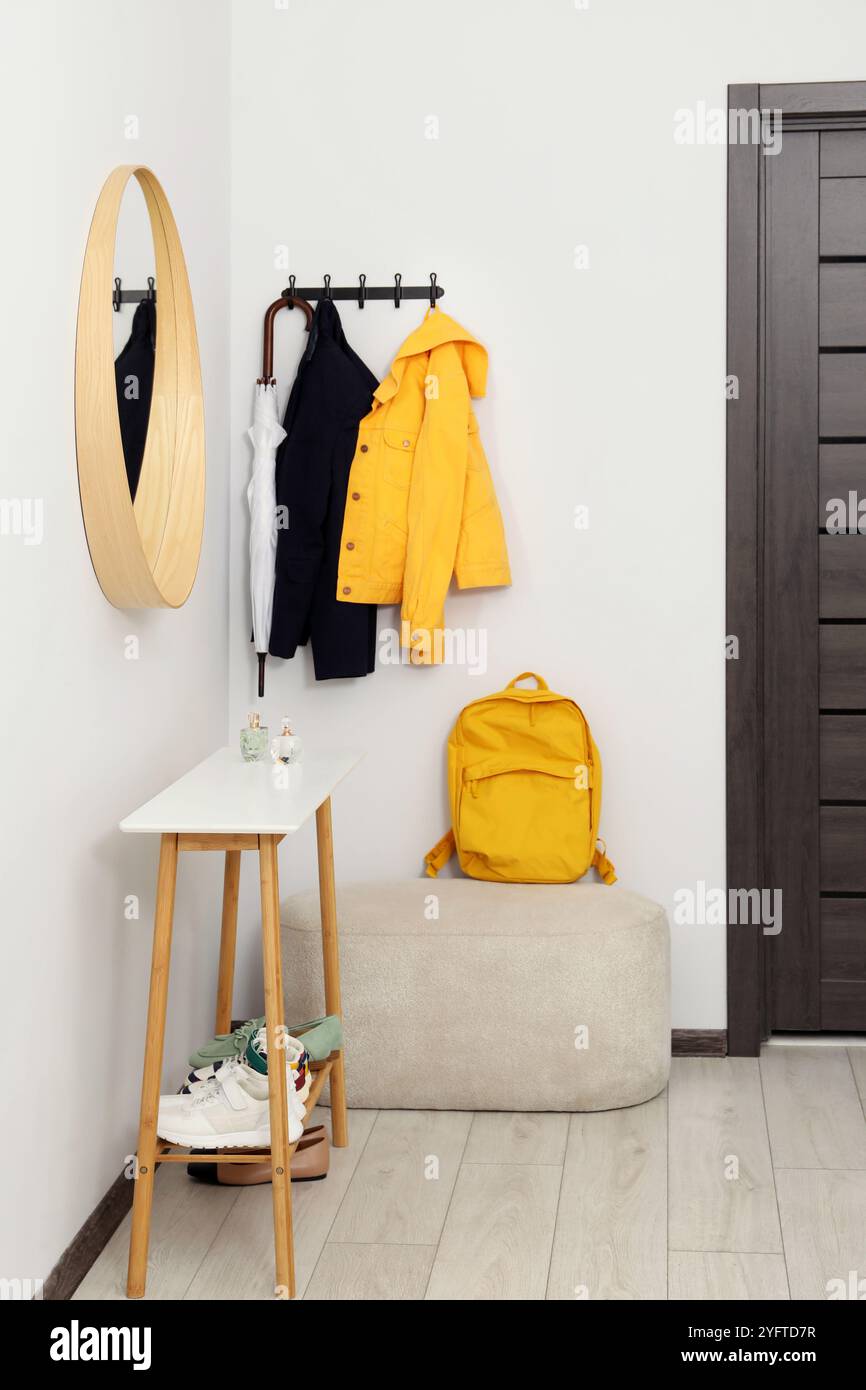 Mirror, rack with clothes and shoe storage bench in hallway. Interior ...