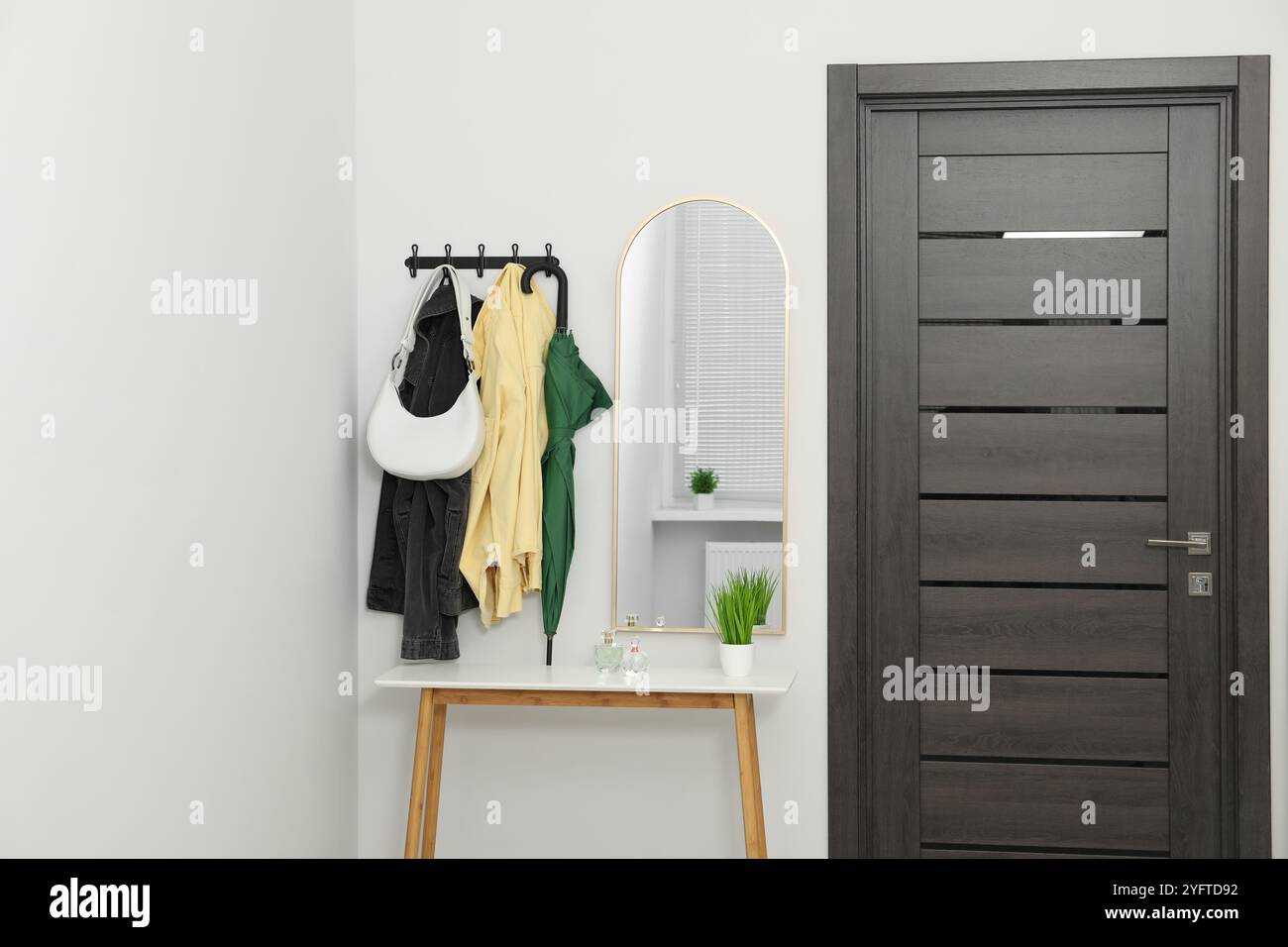 Mirror, rack with clothes and shoe storage bench in hallway. Interior ...