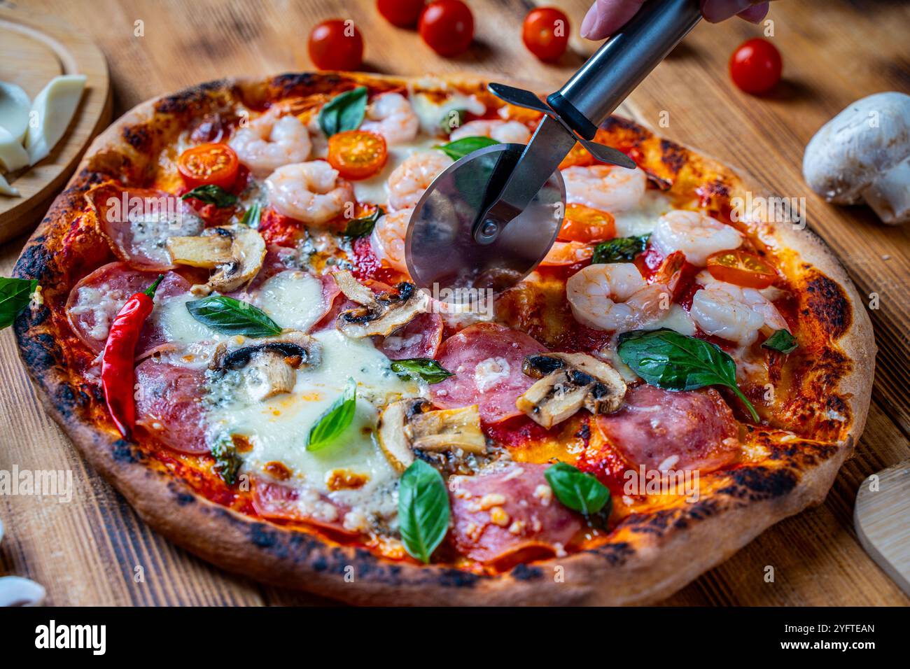 Pizza with two types of toppings: one half with shrimp and tomatoes ...