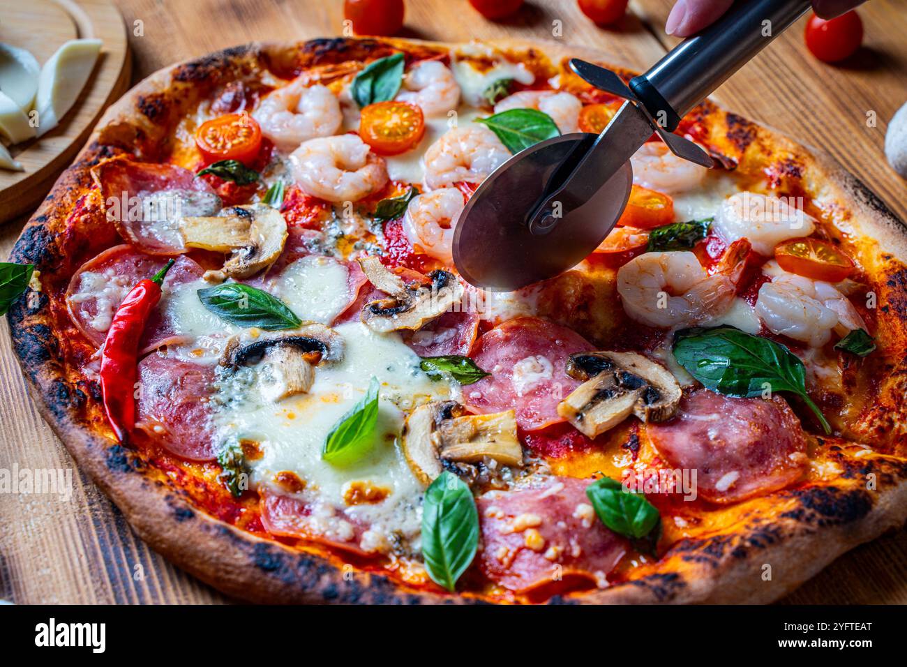 Pizza with two types of toppings: one half with shrimp and tomatoes ...