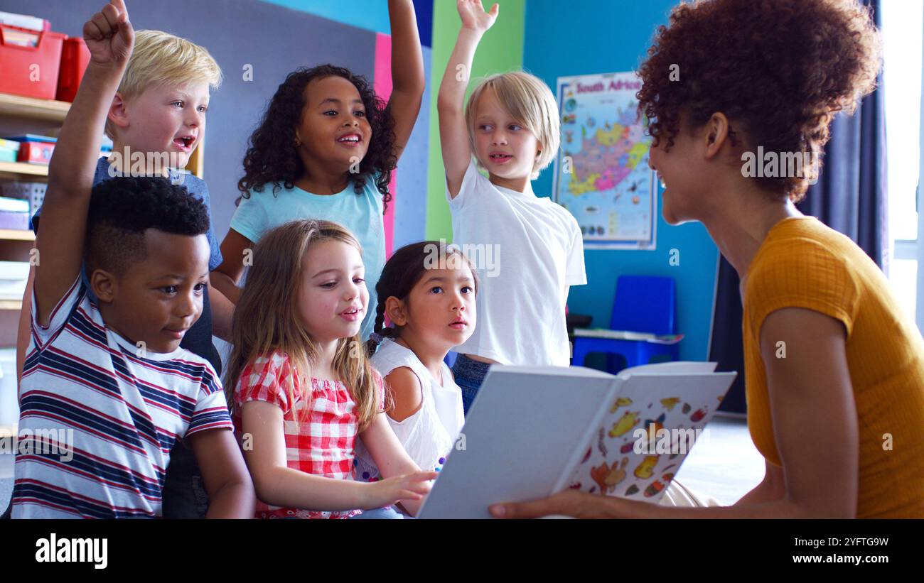 Elementary Pupils Raising Hands To Answer Question As Female Teacher ...