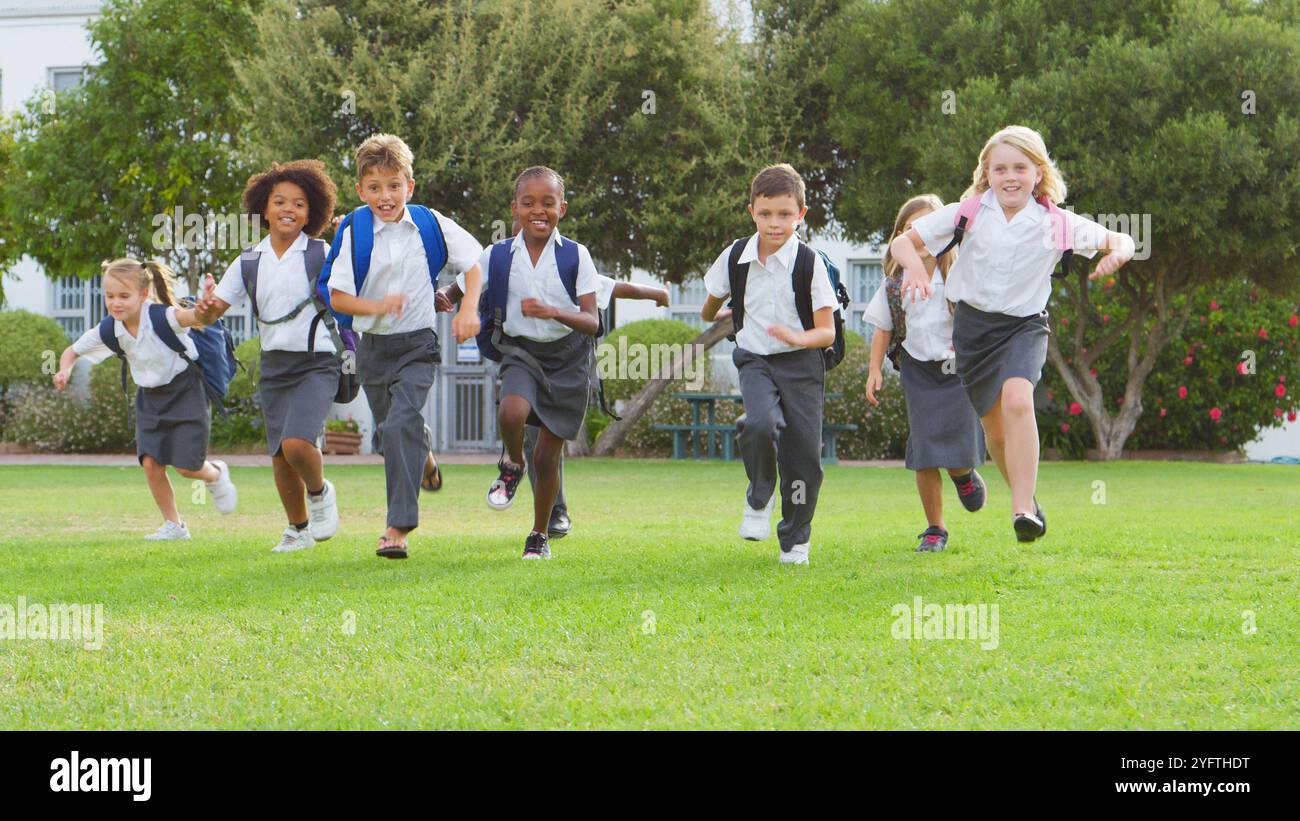 Excited Elementary School Pupils Wearing Uniform Running Across Field ...