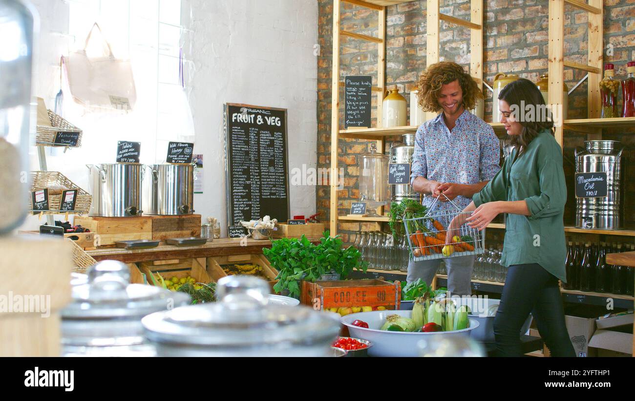 Young Couple Buying Fresh Fruit And Vegetables In Sustainable Plastic ...