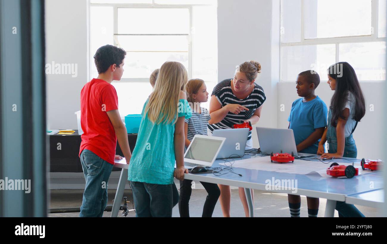 Group Of Students With Female Teacher In School Computer Coding Class Learn To Program Robot ...