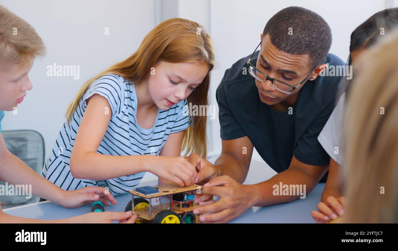 Students With Male Teacher In School Computer Class Building And Programming Robot Vehicle Stock ...