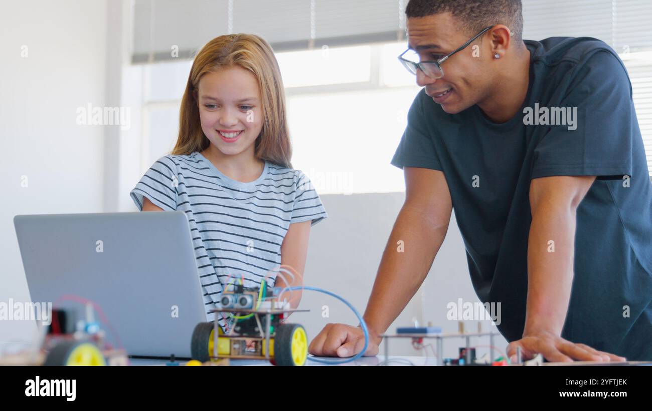 Female Student With Teacher With Laptop Building Robot Vehicle In School Computer Coding Class ...