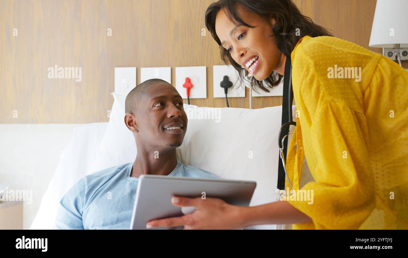 Female Doctor With Digital Tablet Talking With Young Man In Private ...