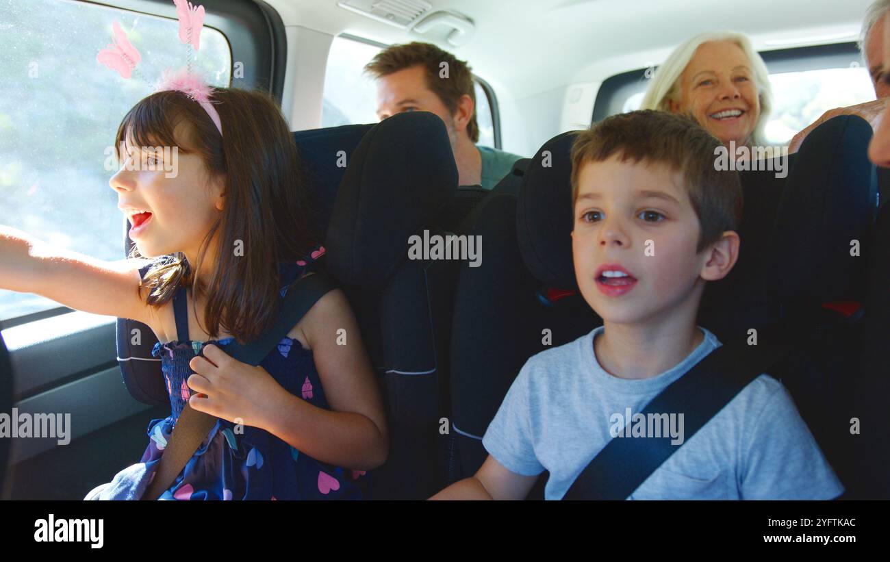 Multi Generation Family Sitting In Back Of People Carrier Being Driven ...