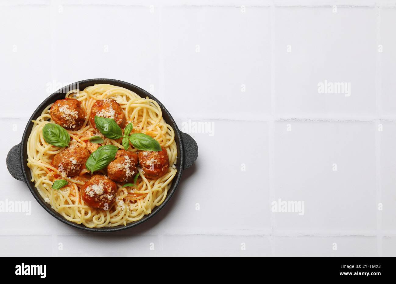 Delicious pasta with meatballs on white tiled table, top view. Space ...