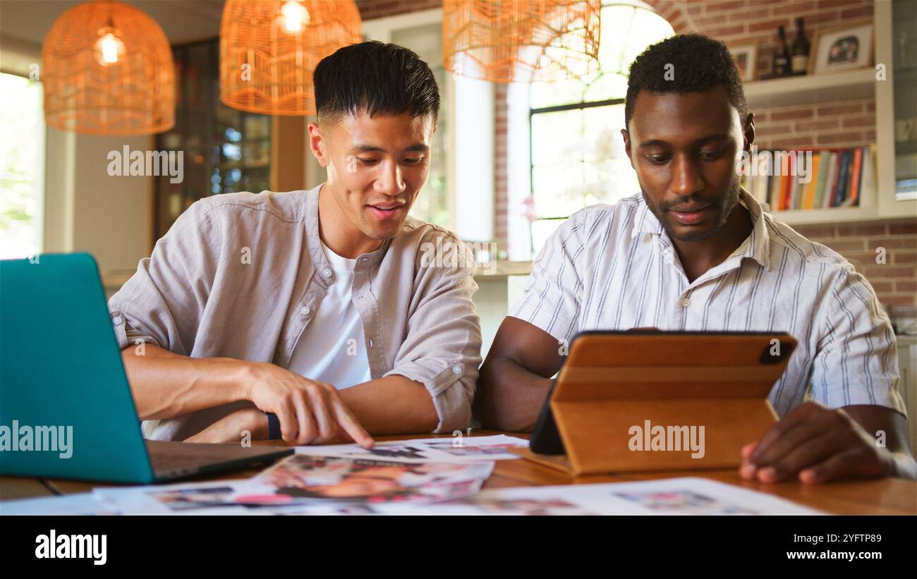 Two individuals sit at a bright table engaging in a collaborative ...