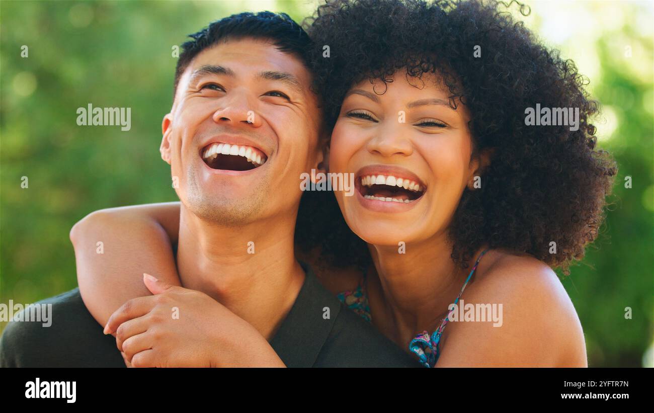 Couple laughing and embracing each other outdoors in a sunny setting ...