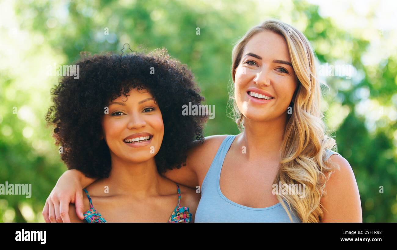 Two smiling friends pose together in a vibrant outdoor environment ...