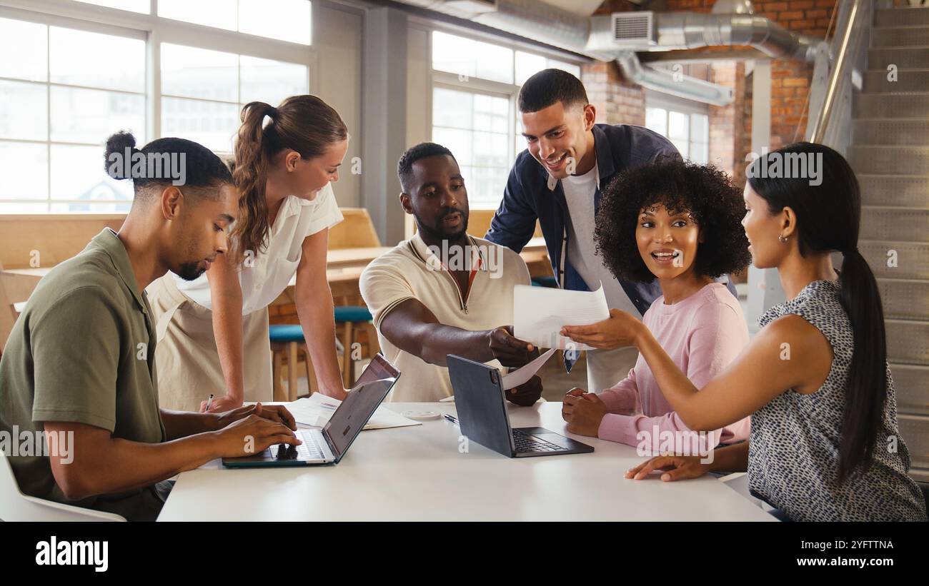Multi-Cultural Business Team Meeting Around Desk In Modern Open Plan ...