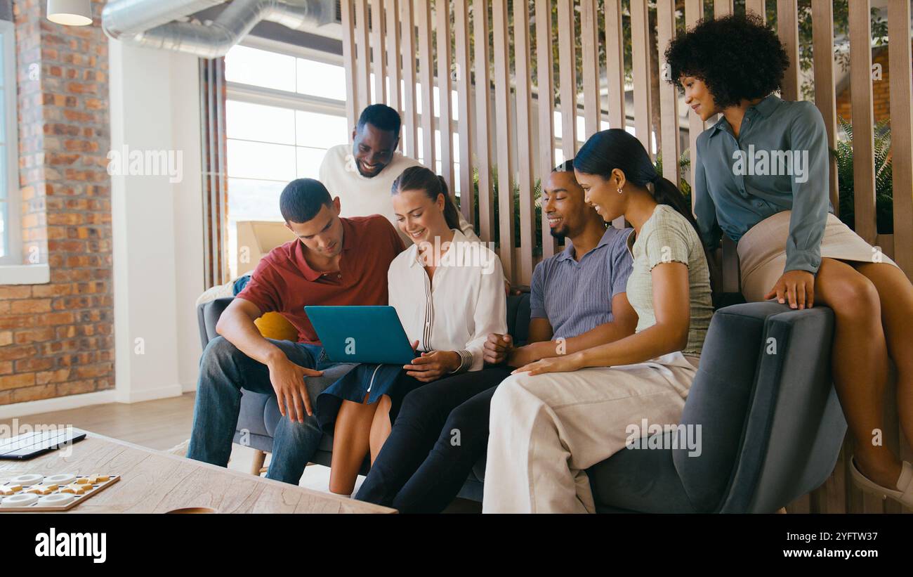 Multi-Cultural Business Team Sitting On Couch In Modern Open Plan ...