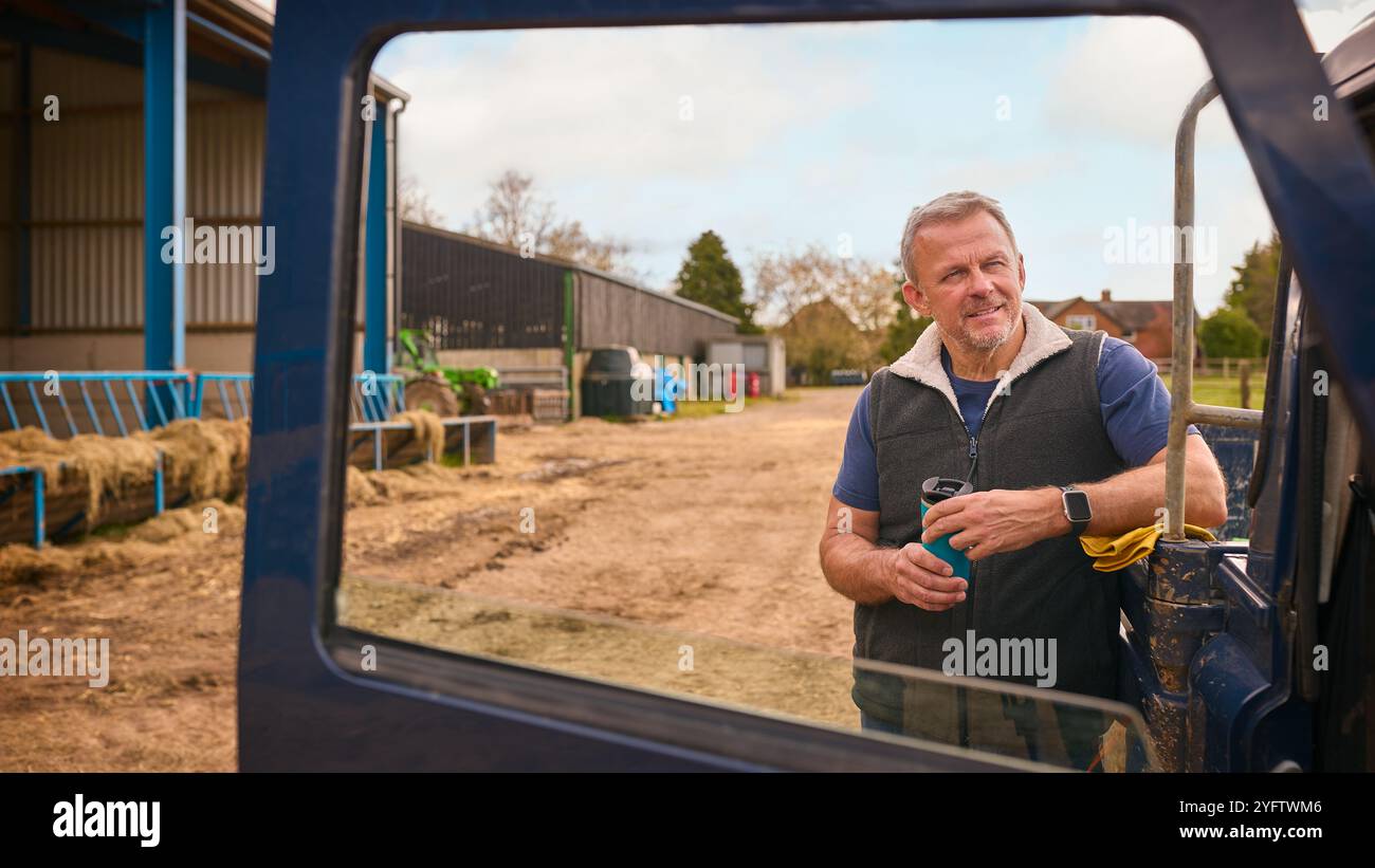 Male Farm Worker Holding Cup In Yard Viewed Through Window Of Farm Off ...