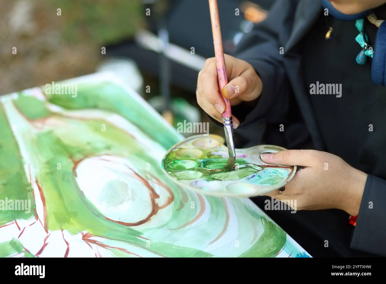 moment of an artist at work, showcasing hands holding a brush and ...