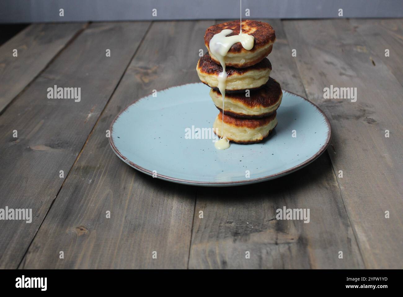 Drops of condensed milk drip from cheesecakes on a plate. nasser ...
