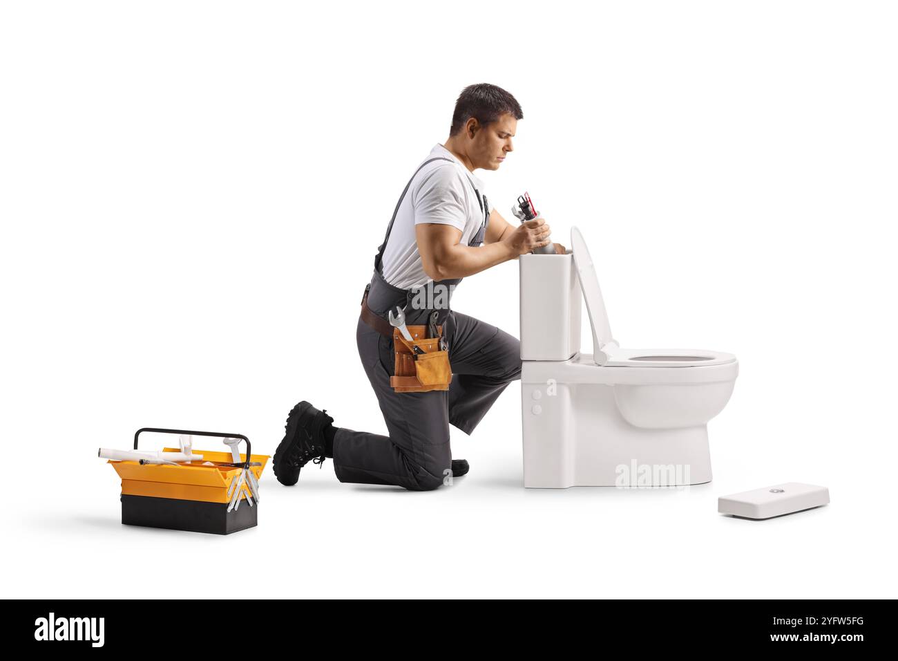 Plumber with a tool box fixing a toilet tank isolated on white ...