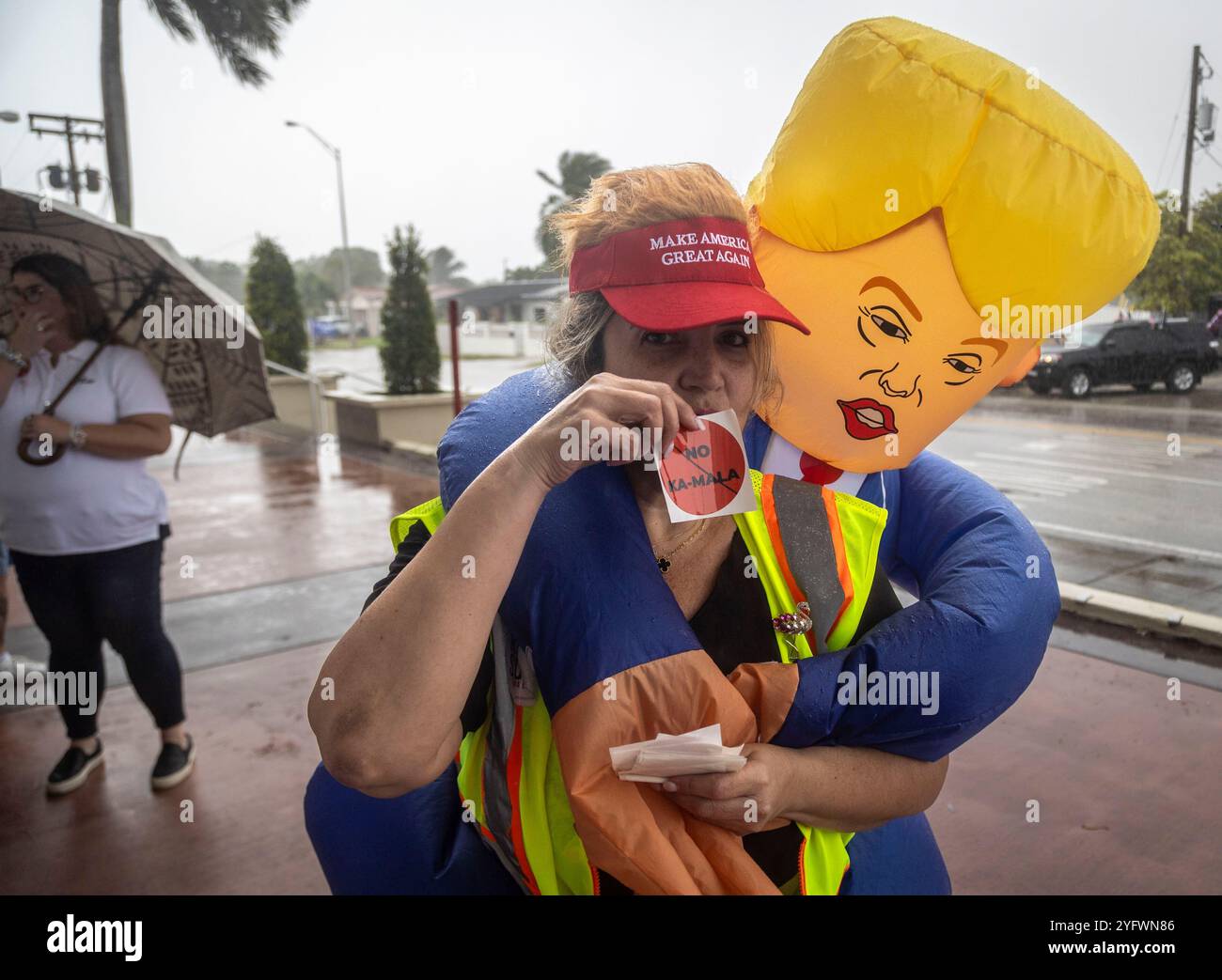 Maria "Millie" Negron offers up No Ka-mala stickers to people seeking ...