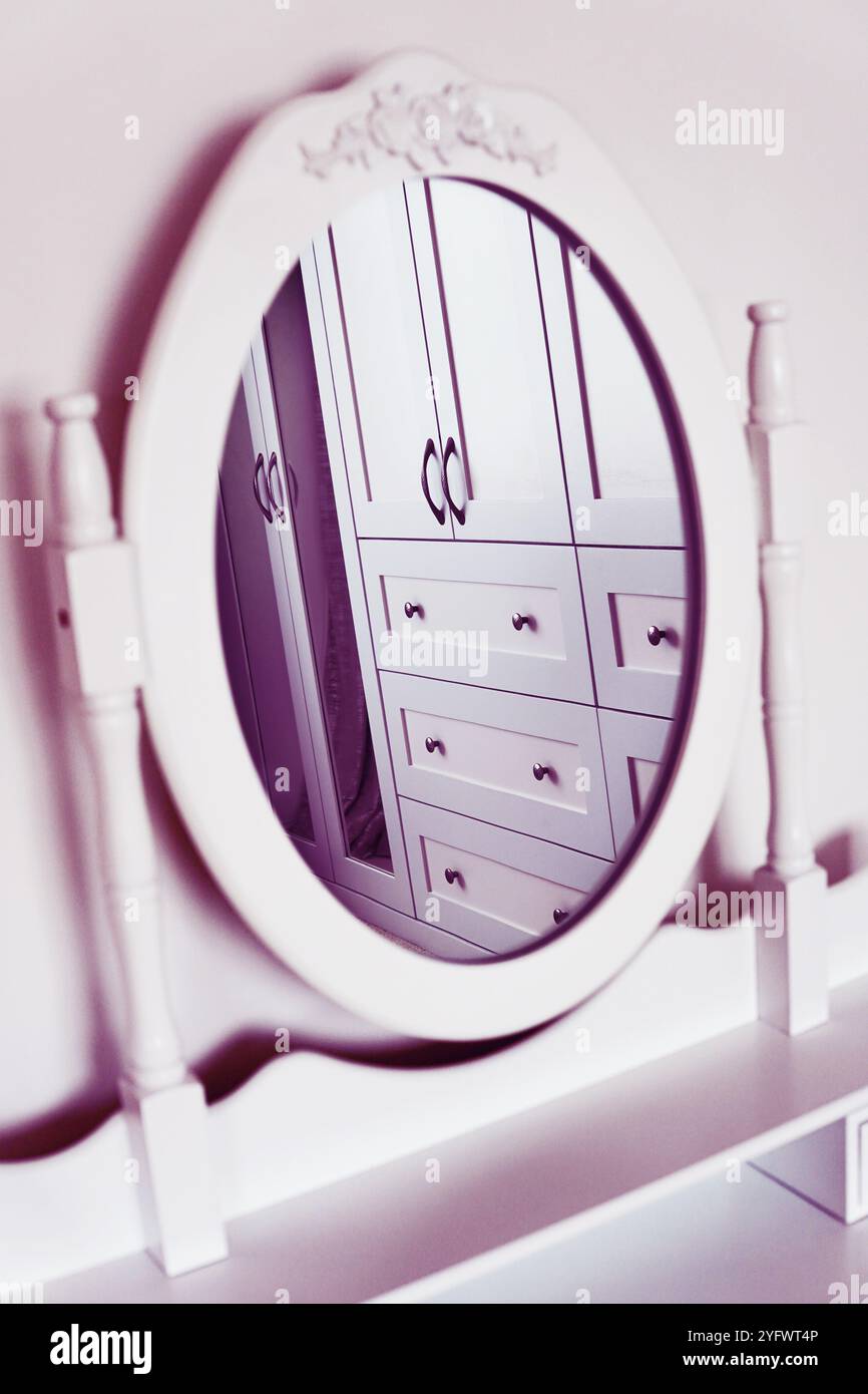 Reflection of a wardrobe in the mirror of a pure white Dressing Table ...