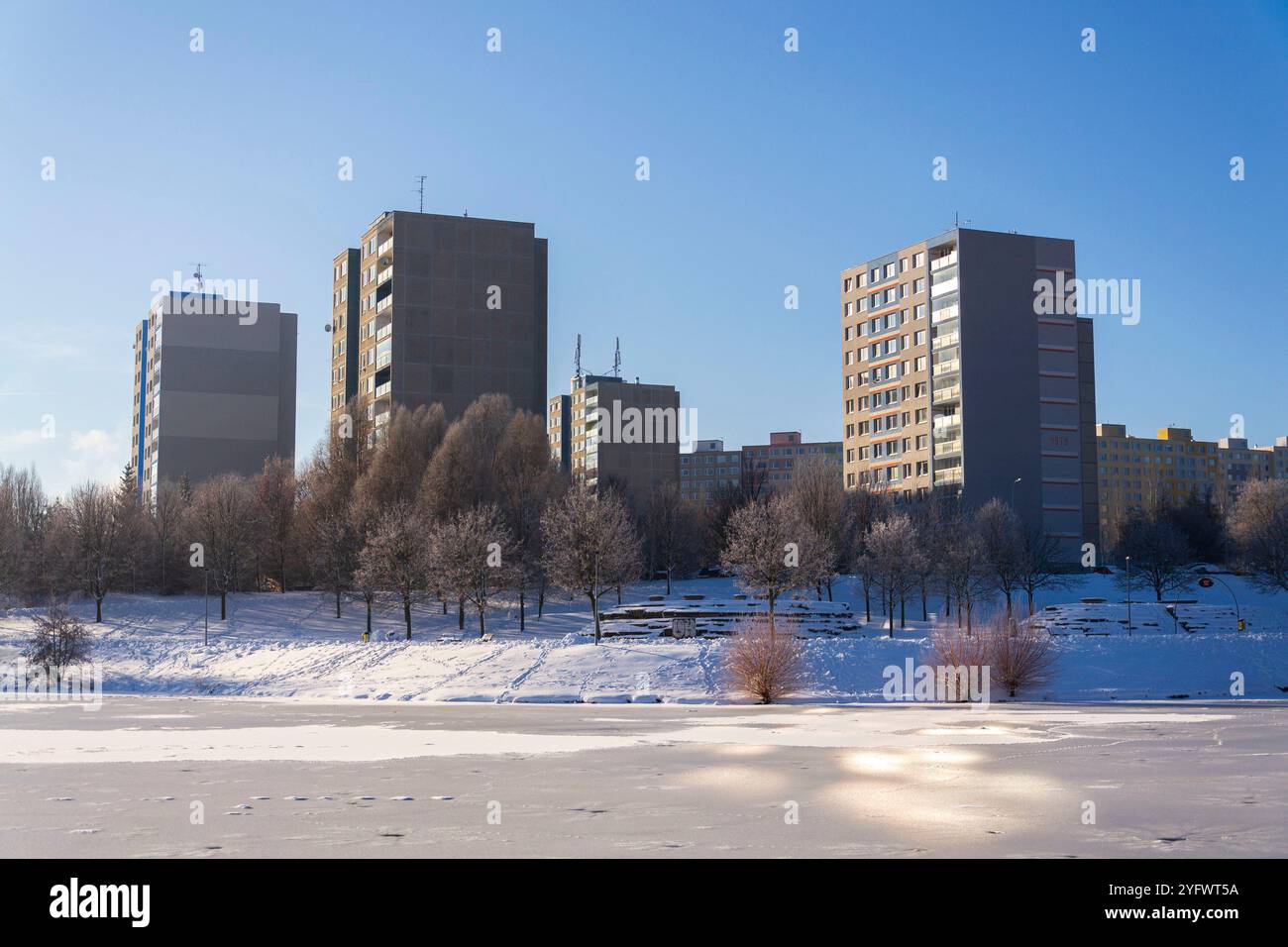 Insulated panel house apartments behind trees, high-rise block of flats ...