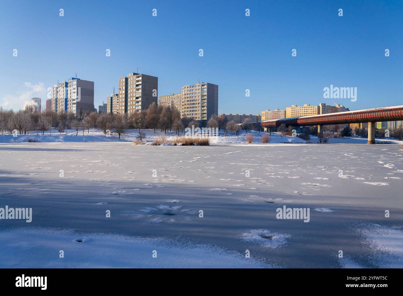 Insulated panel house apartments behind trees, high-rise block of flats ...