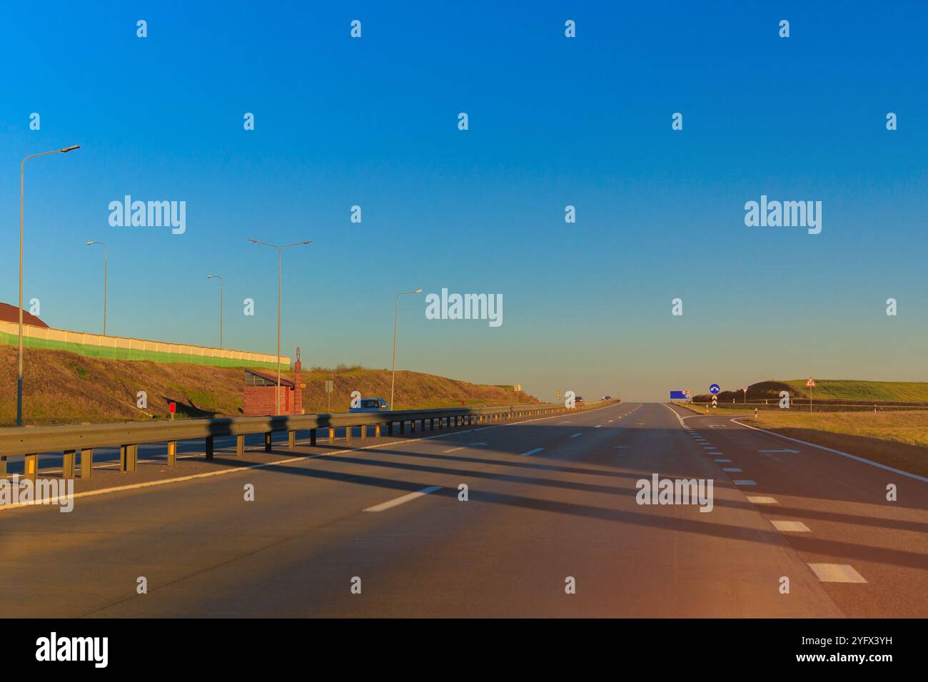 Evening view at sunset. Highway road in the countryside, roadside and ...