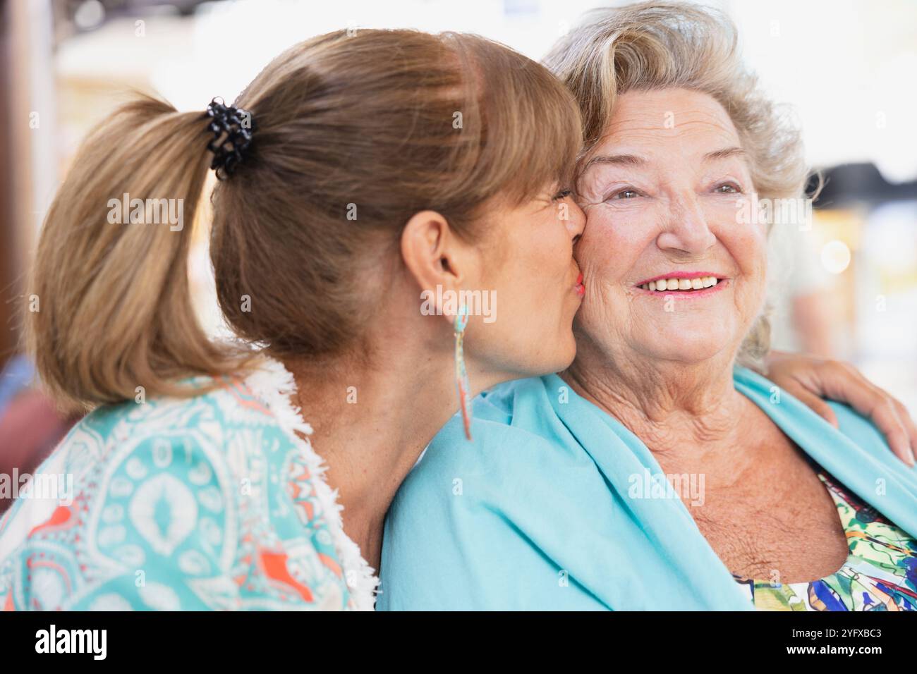 Heartwarming moment of a daughter showing affection with a kiss to her elderly mother Stock ...