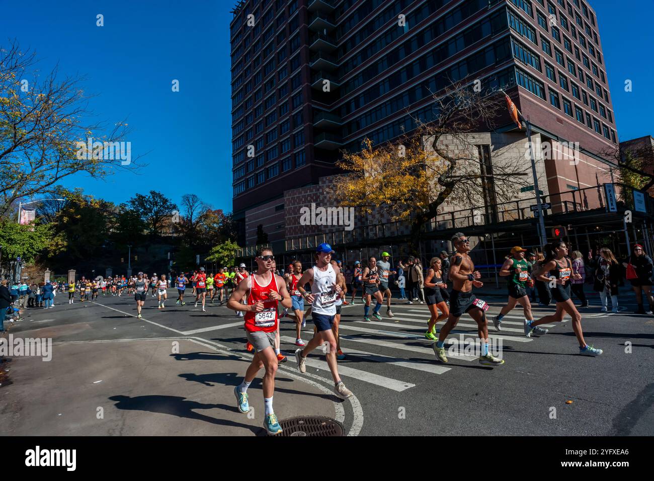 Runners pass through Harlem in New York near the 22 mile mark near ...