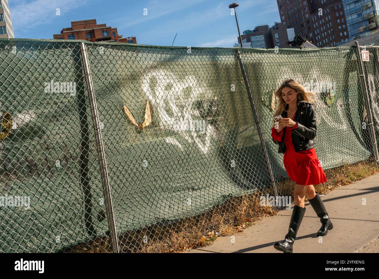 Distracted woman in Hudson Square in New York walks past construction ...
