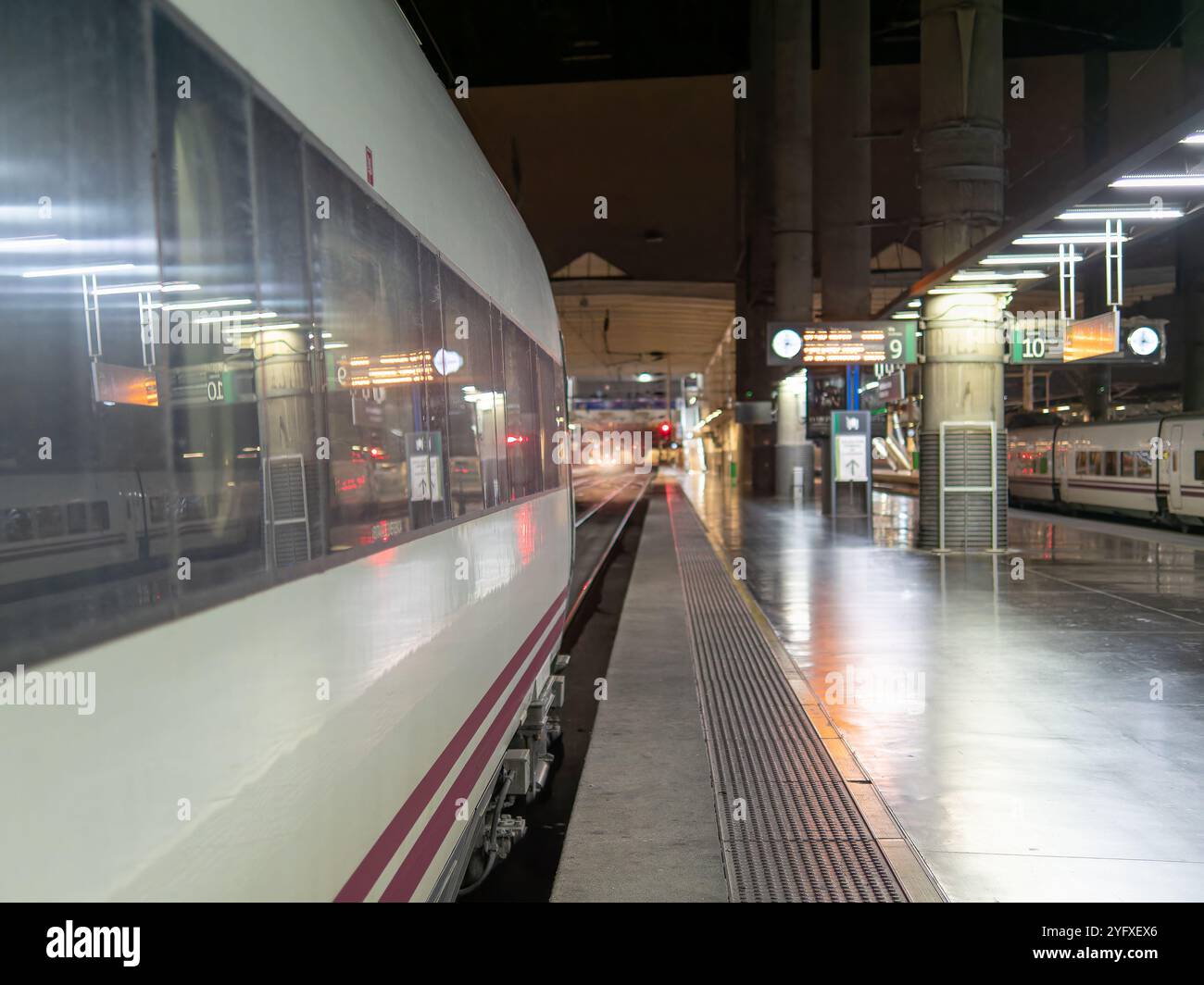 Modern train at illuminated railway station platform Stock Photo - Alamy