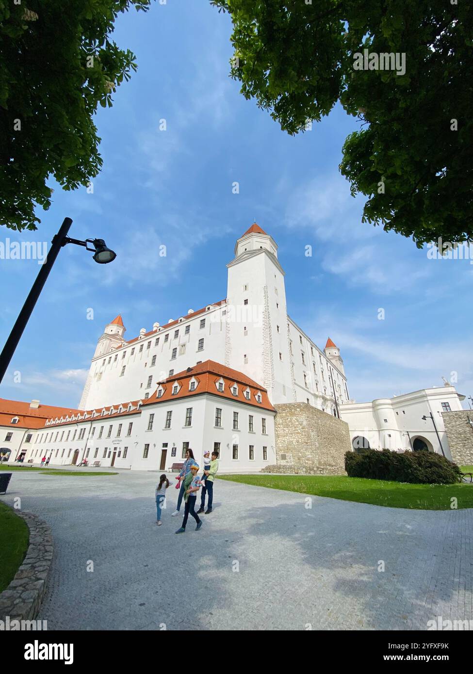 A group of tourists walks through the grounds of a historic Bratislava ...